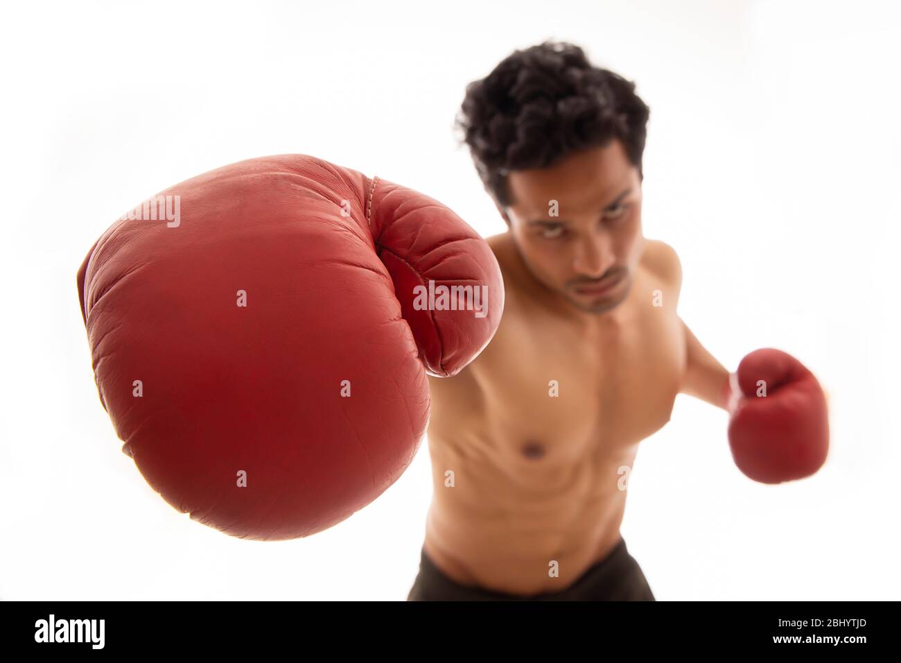Man throwing punch in the air while wearing boxing gloves in front of a ...