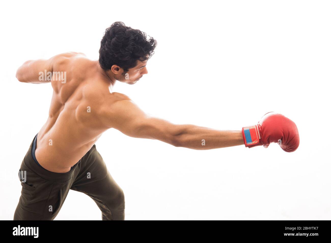 Man throwing punch in the air while wearing boxing gloves in front of a ...