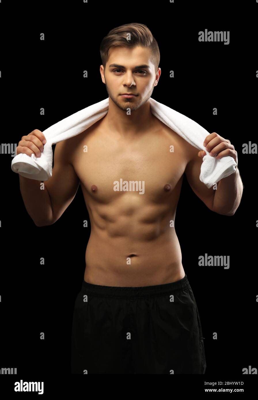 Muscle young man holding towel on dark background Stock Photo - Alamy