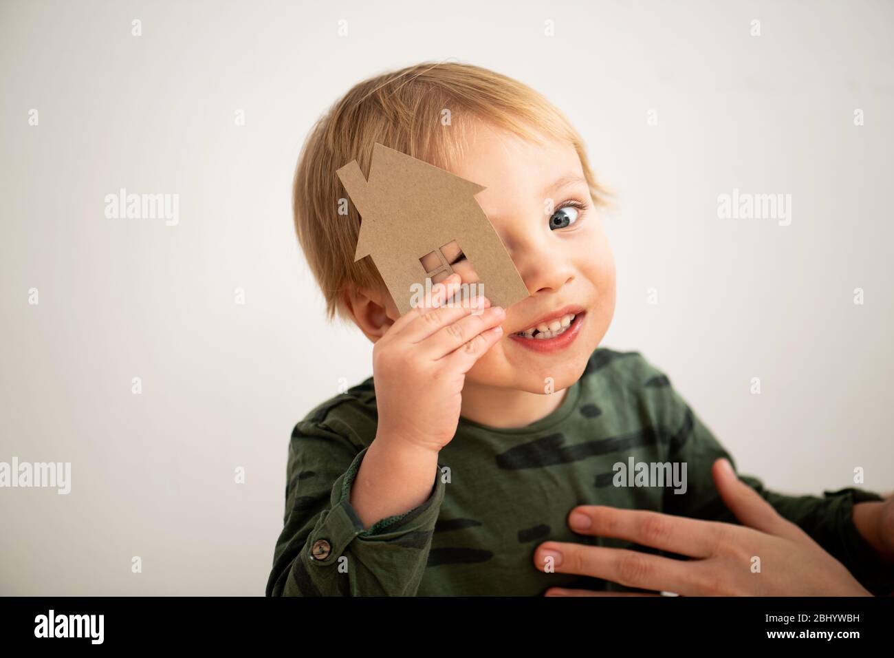 Clumsy toddler boy trying to look through paper house window Stock ...