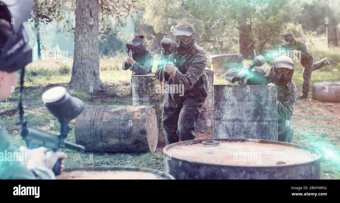 Two active opposing teams with guns playing paintball against each ...