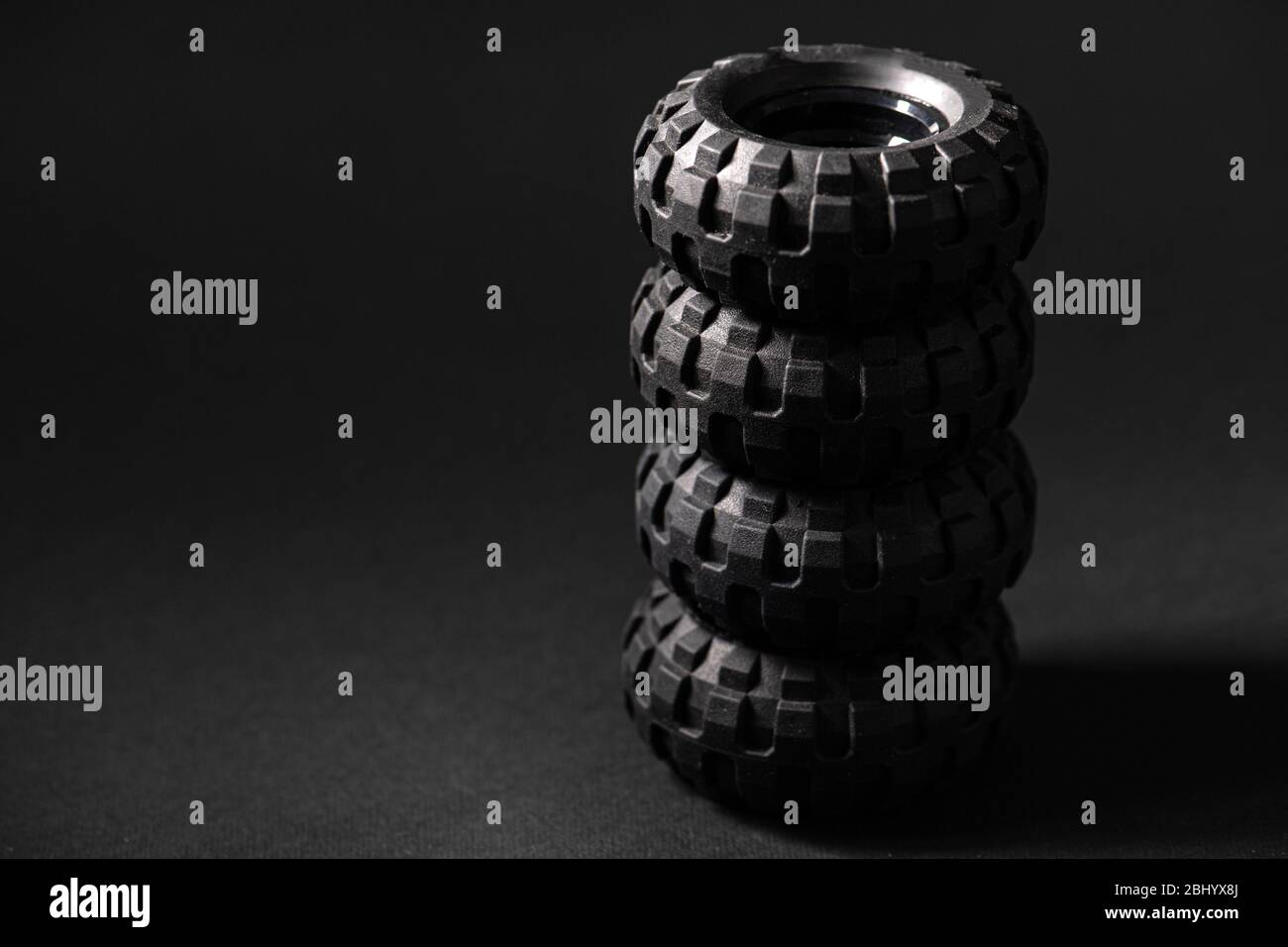 Stack of toy tires close up over black background Stock Photo - Alamy