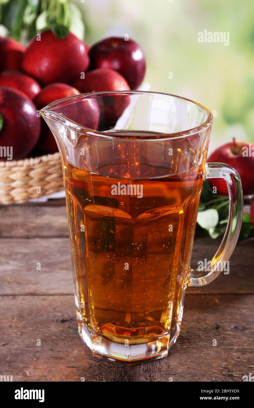 Full jug of apple juice and fruits on bright background Stock Photo - Alamy