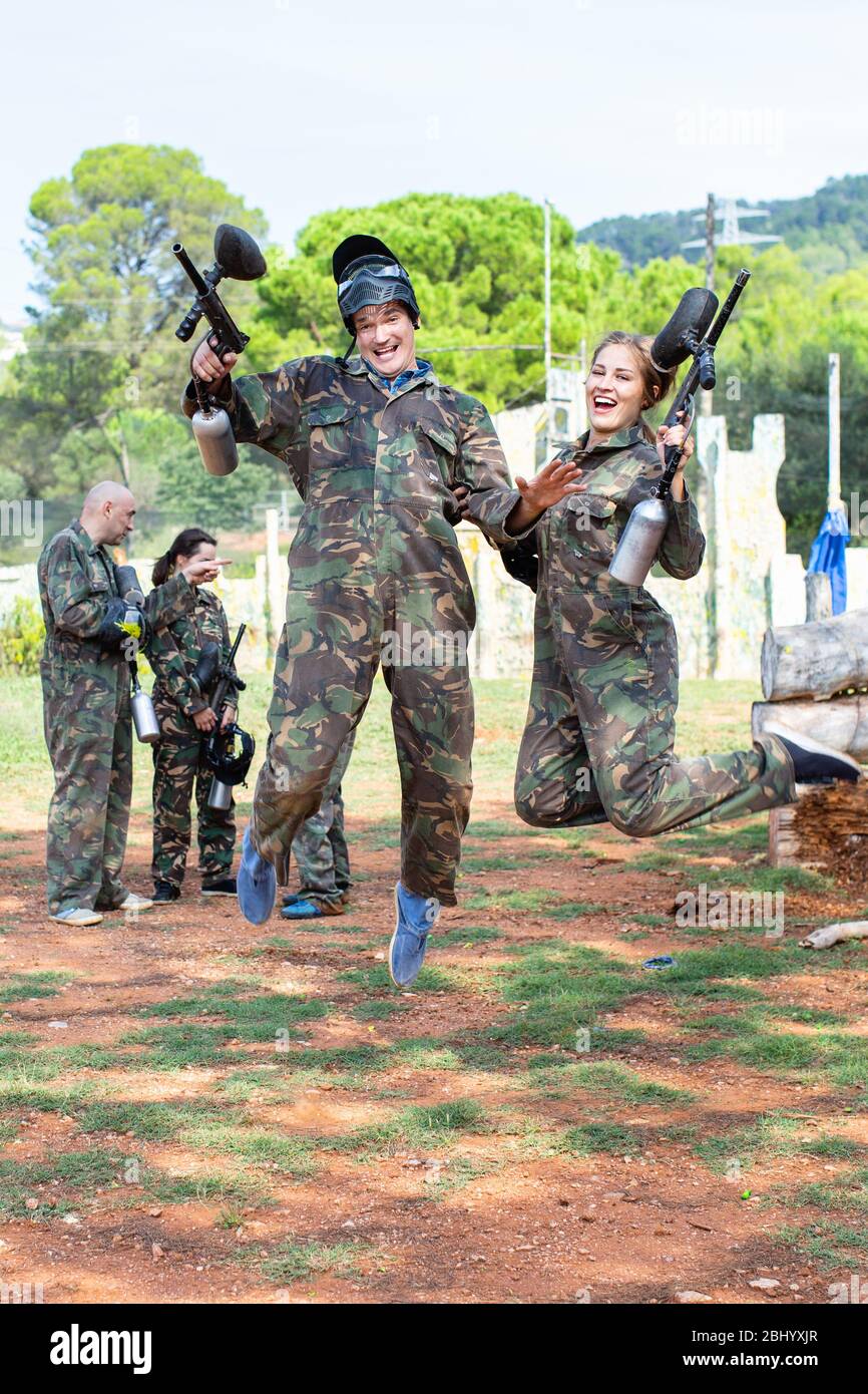 Portrait of satisfied positive smiling man and woman paintball players ...