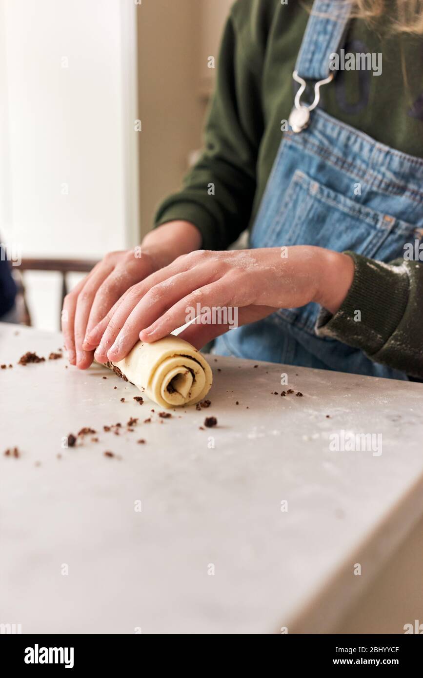 Anonymous girl baking and rolling cinnamon roll Stock Photo - Alamy