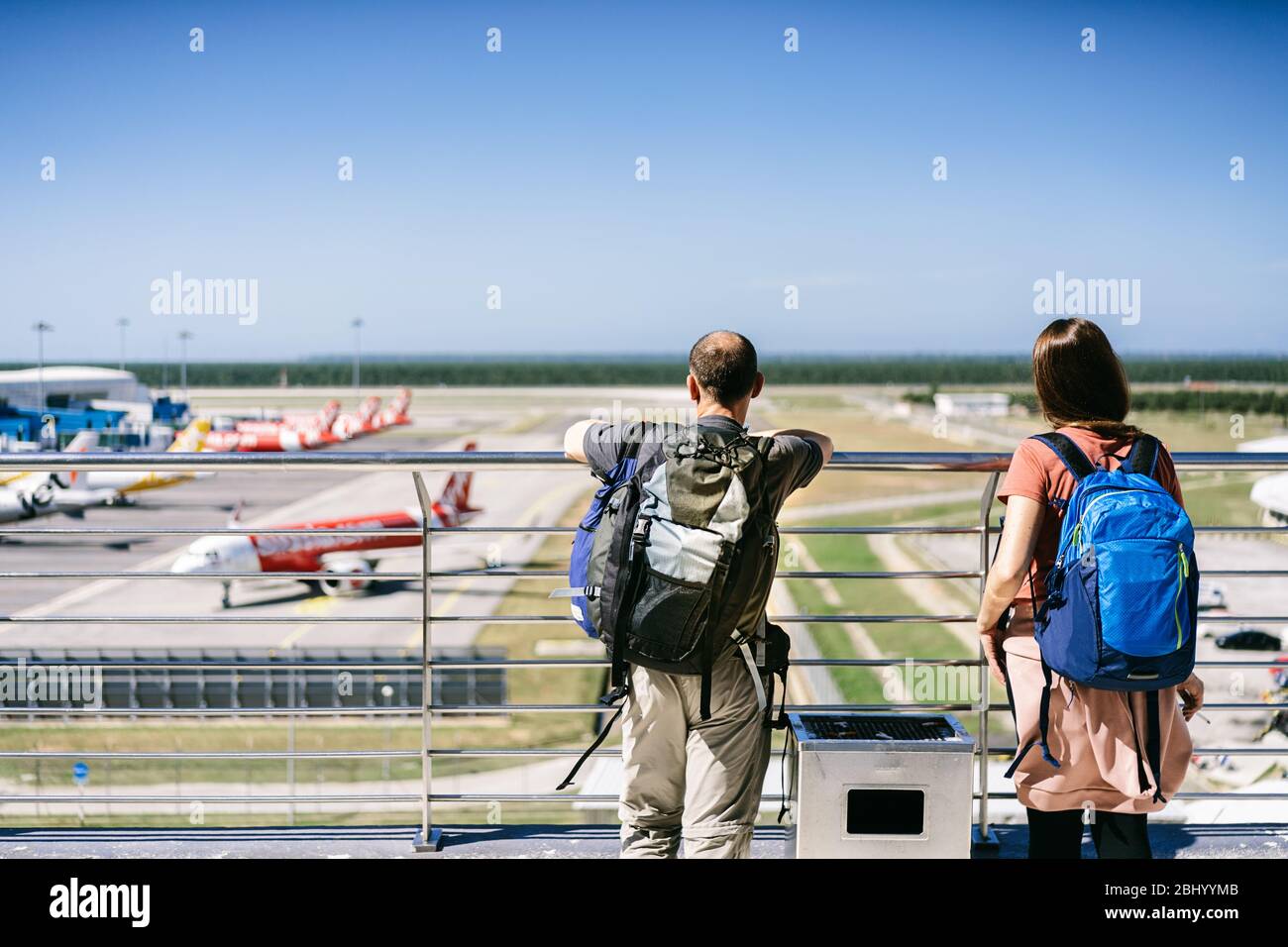 Backpackers at the airport looking at the fleet of planes parked on the ...