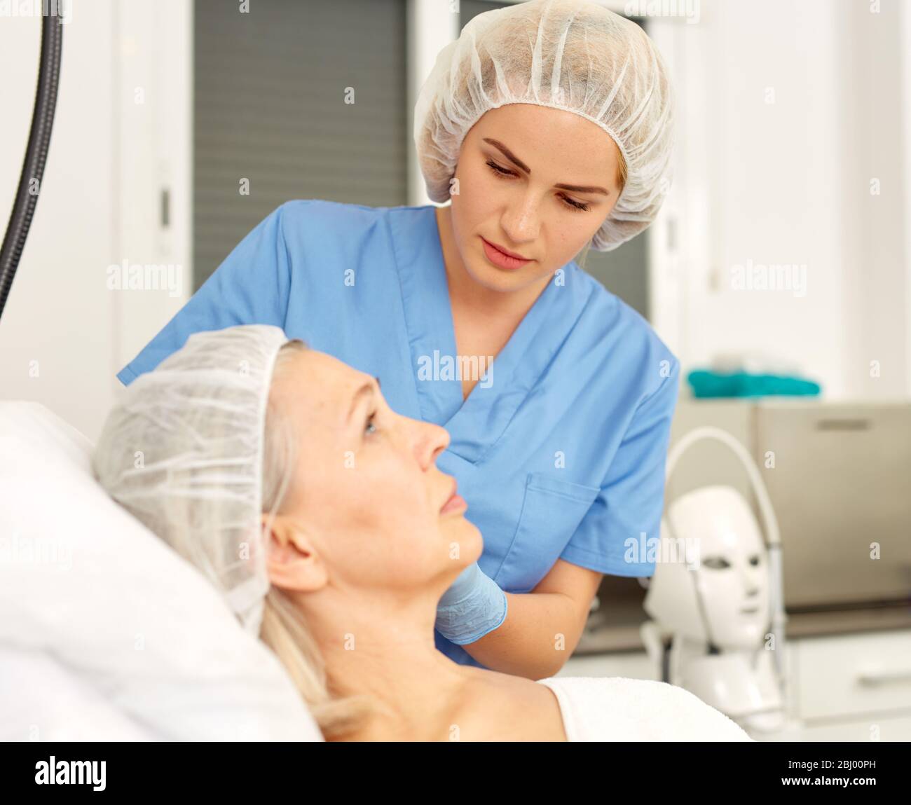 Plastic surgeon preparing for operation on mature woman face Stock ...