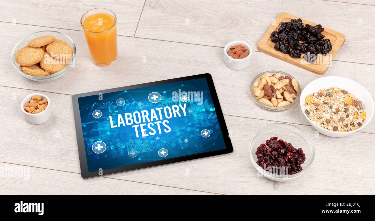 LABORATORY TESTS concept in tablet pc with healthy food around, top ...