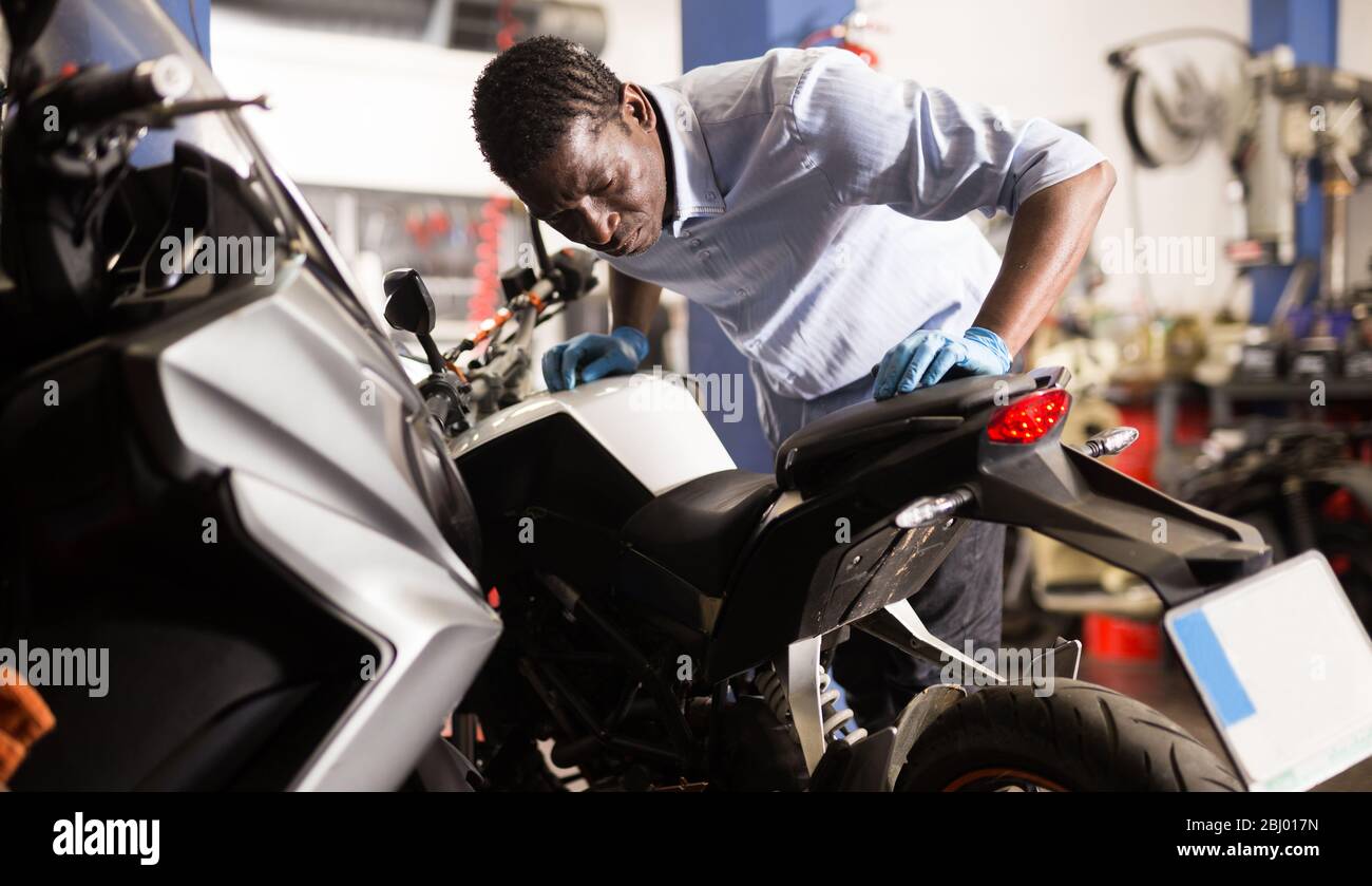 Mechanic is repairing modern moto in the workshop Stock Photo - Alamy