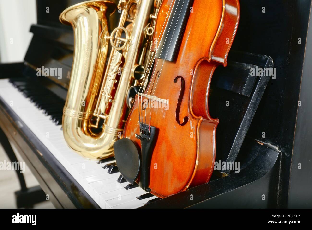 Violin and saxophone on piano background Stock Photo - Alamy