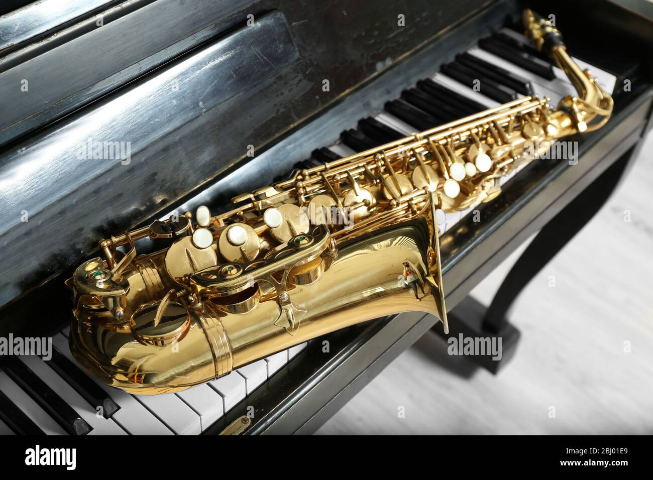 Saxophone on piano keys, closeup Stock Photo - Alamy