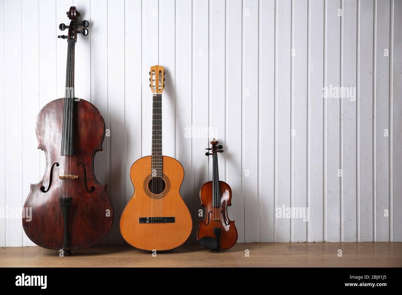 Musical instruments on wooden planks background Stock Photo - Alamy