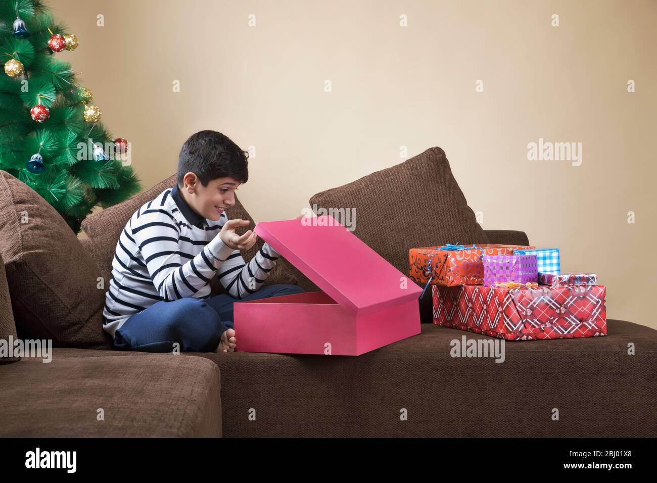 Portrait of a surprised young boy opening a Christmas gift box Stock ...