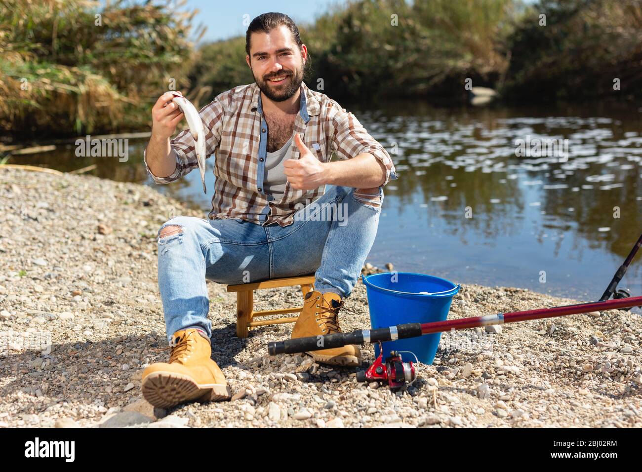 Adult male fisherman holding fish in his hands Stock Photo - Alamy