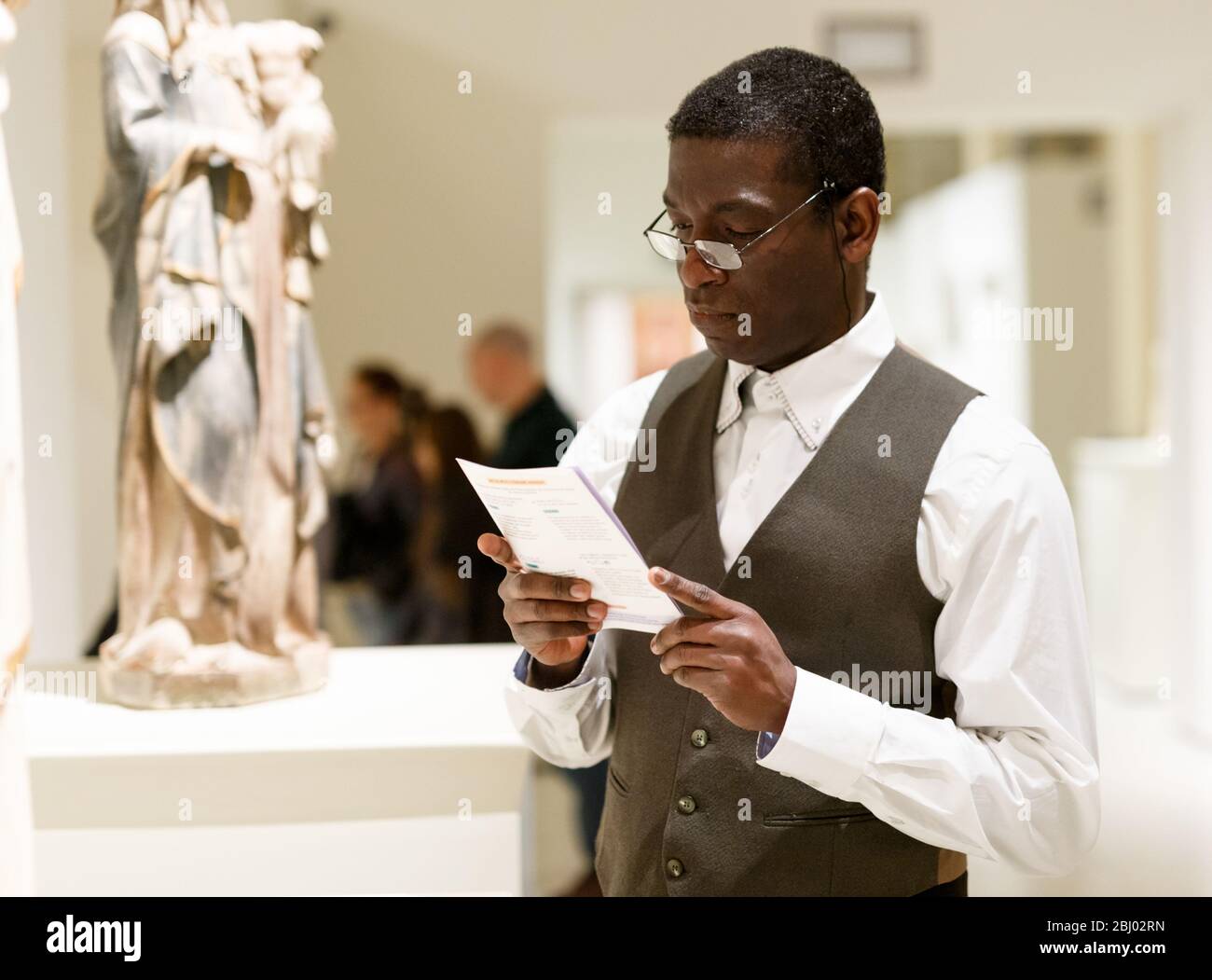 Mature african man reading brochure about exhibits on exposition of ...