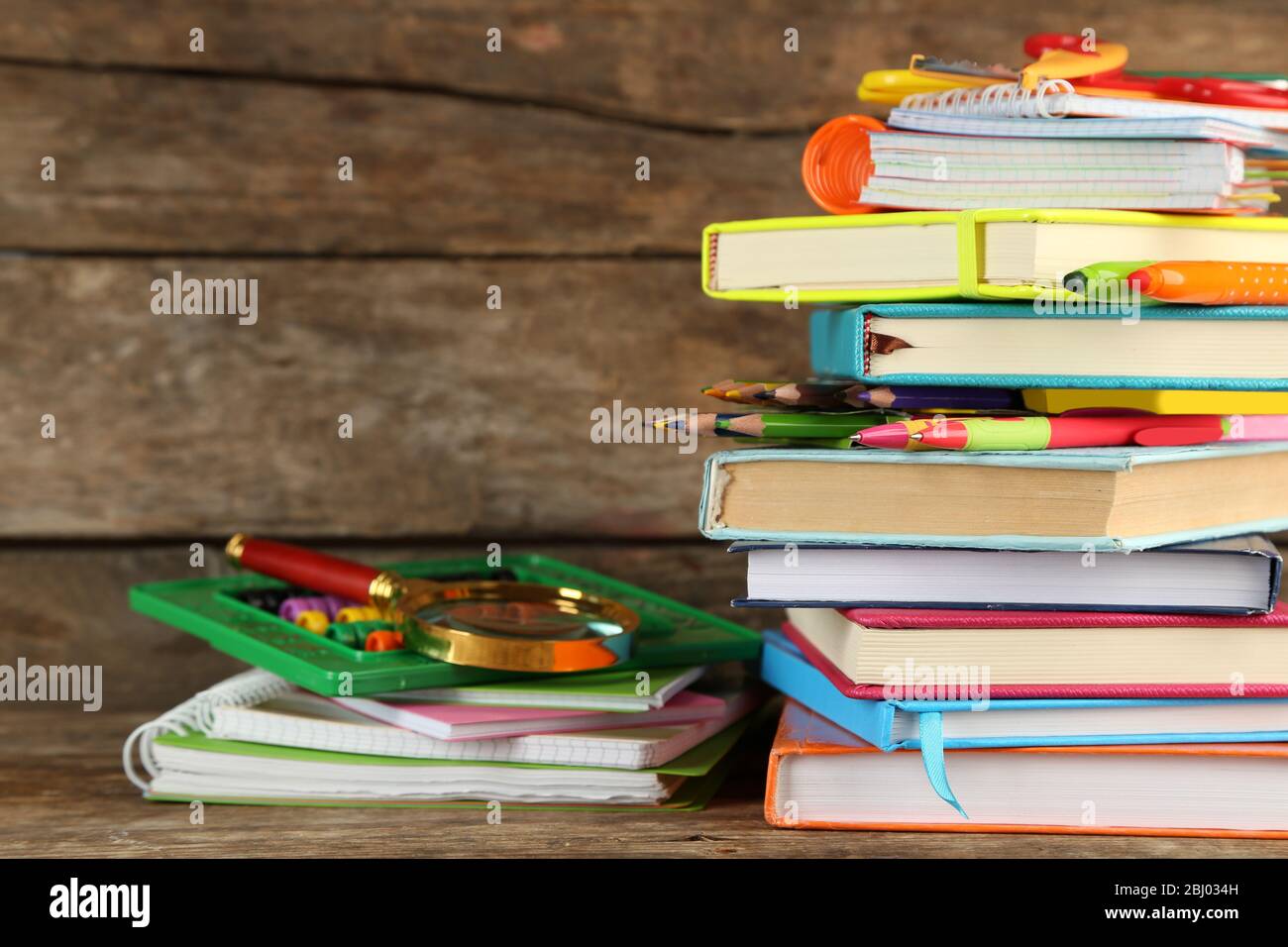 Stack of books and stationery on wooden background Stock Photo - Alamy