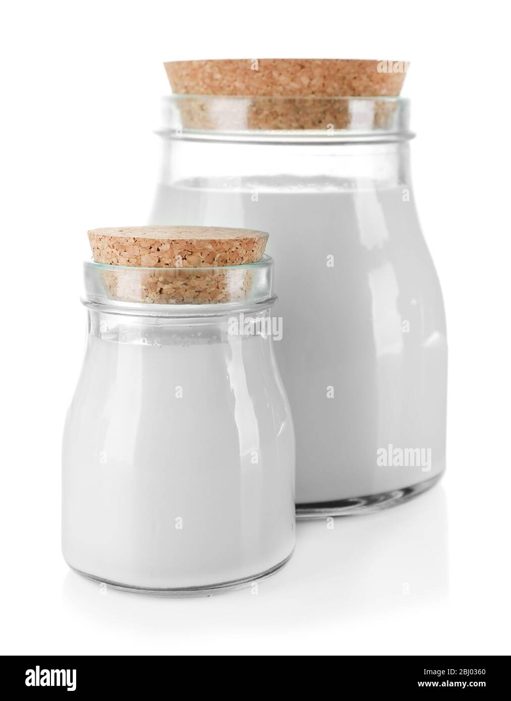 Glass jars of milk on wooden table, on white background Stock Photo - Alamy