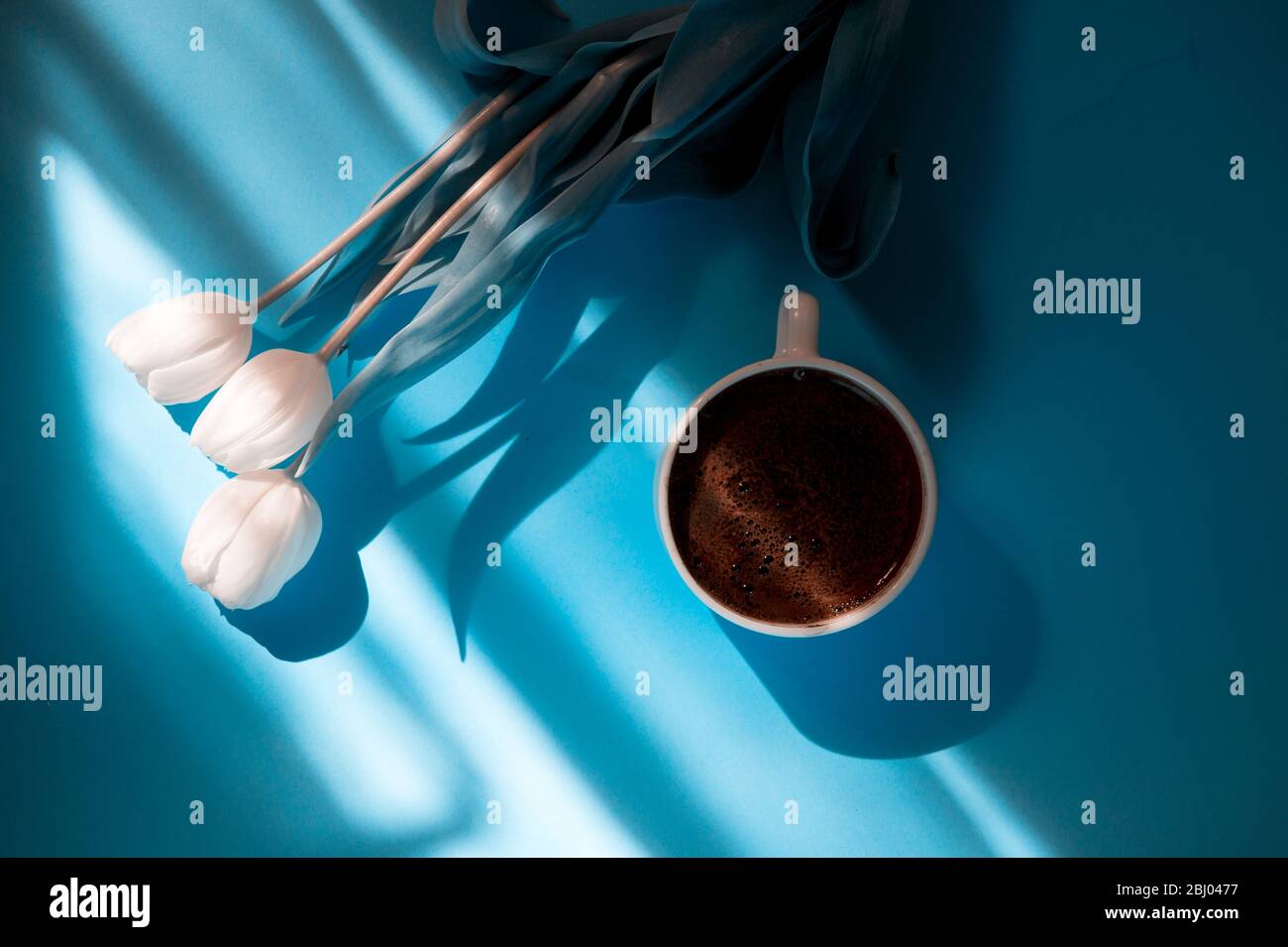 Coffee and spring flowers on blue background. Good mood concept. Blue ...