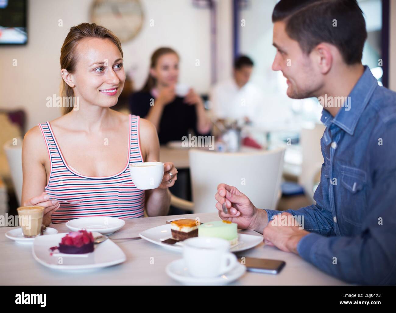 Romantic couple drinking coffee with sweet dessert together at pastry ...