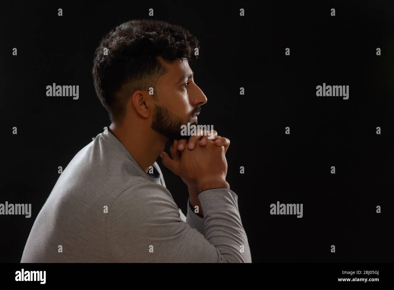 Young sad man praying hi-res stock photography and images - Alamy