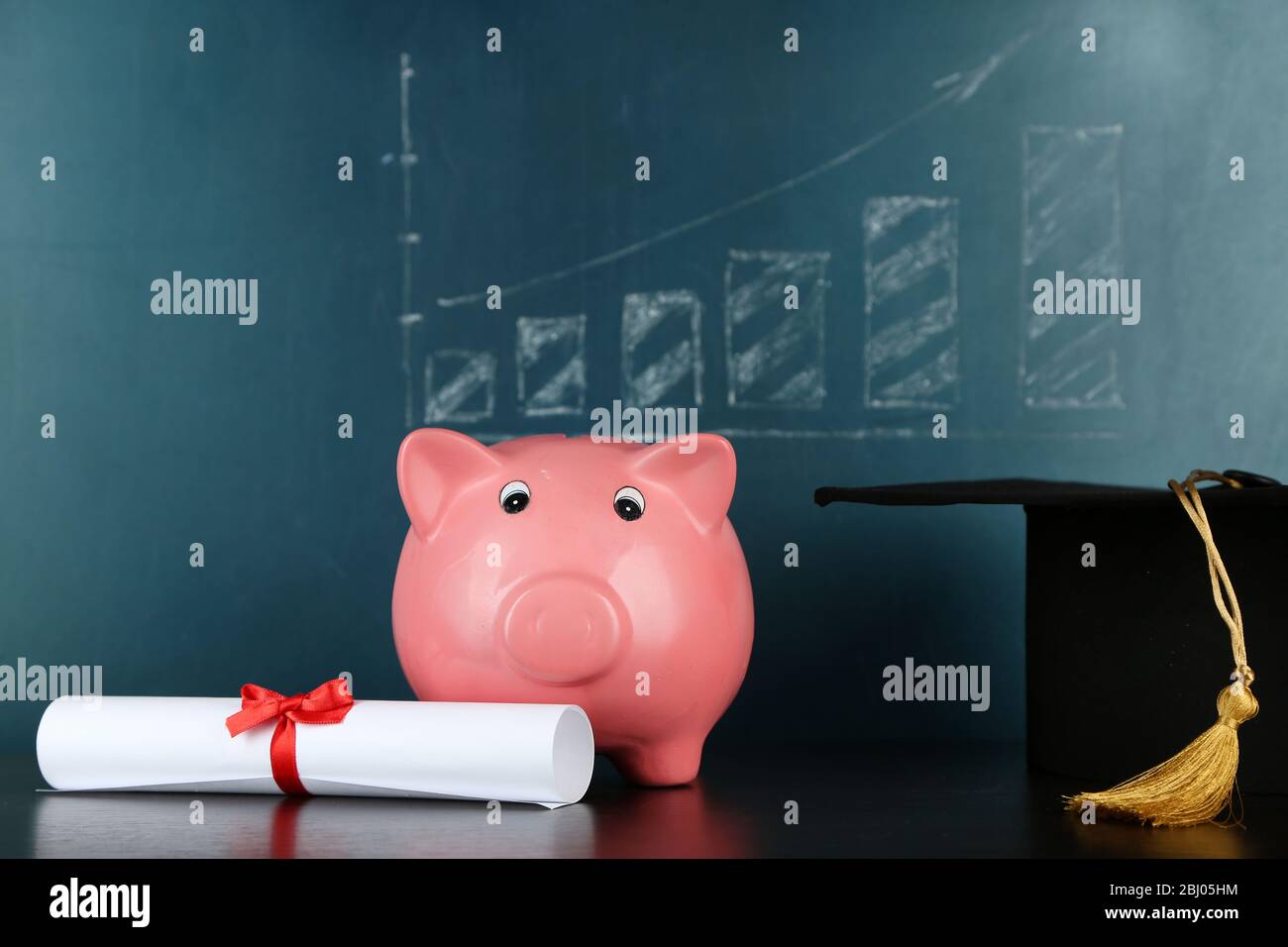 Piggy bank with grad hat and diploma on blackboard background Stock ...