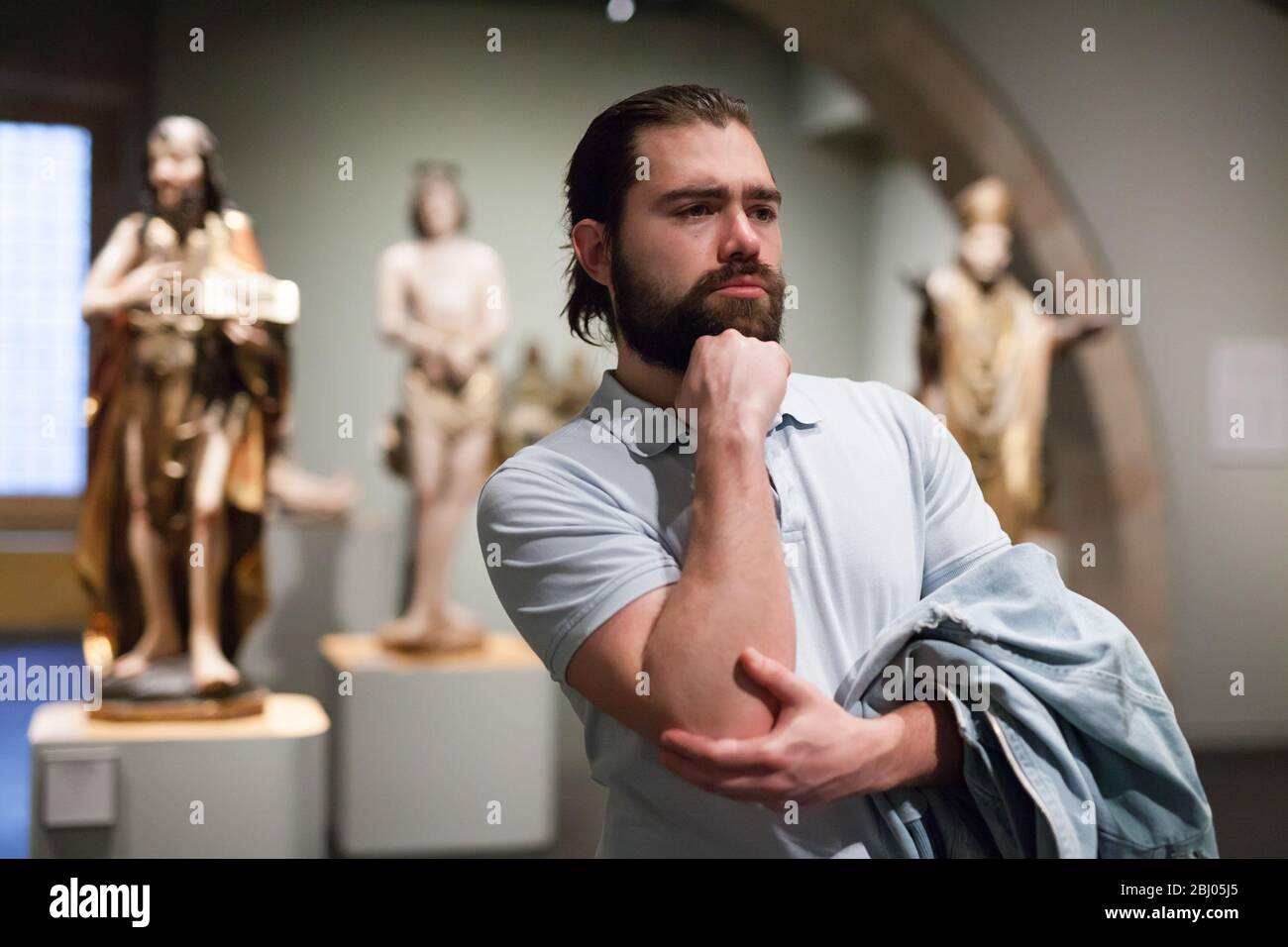 Man visiting sculpture hall in historical museum and looking at ...