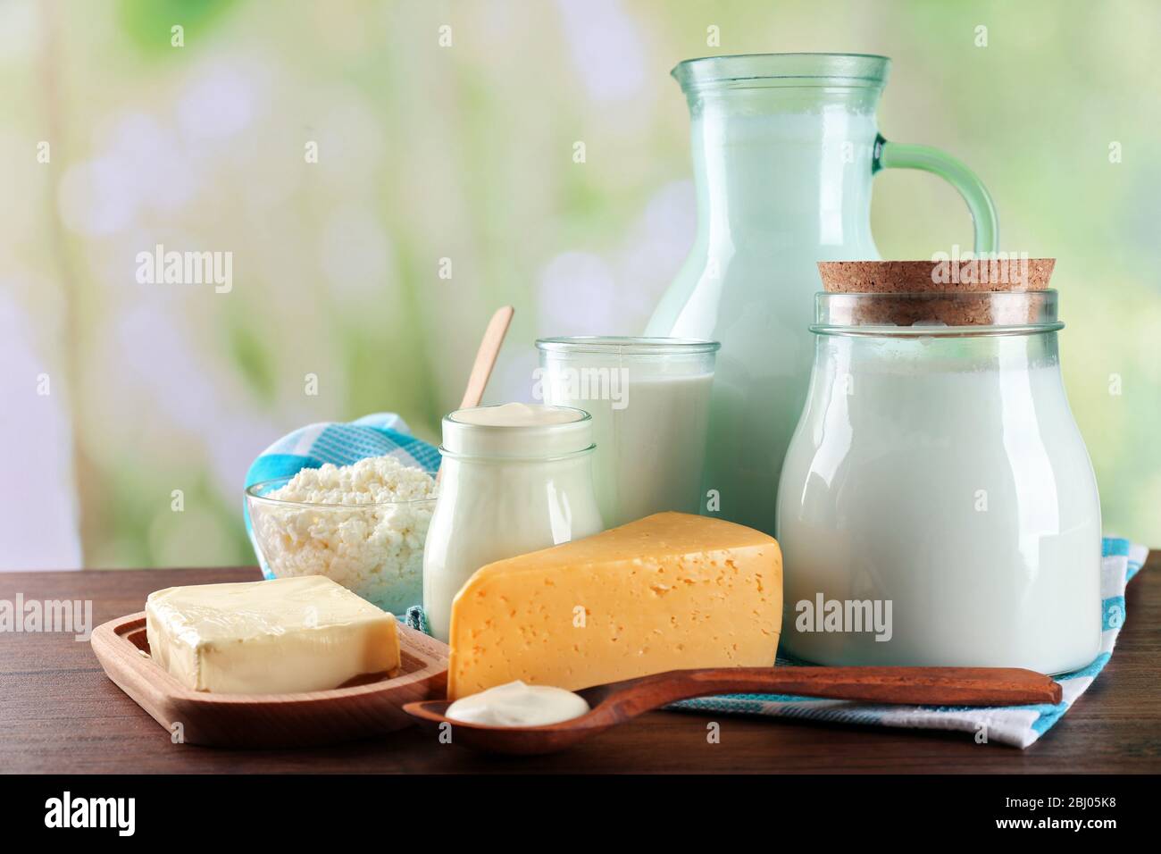Dairy products on wooden table, on green nature background Stock Photo ...
