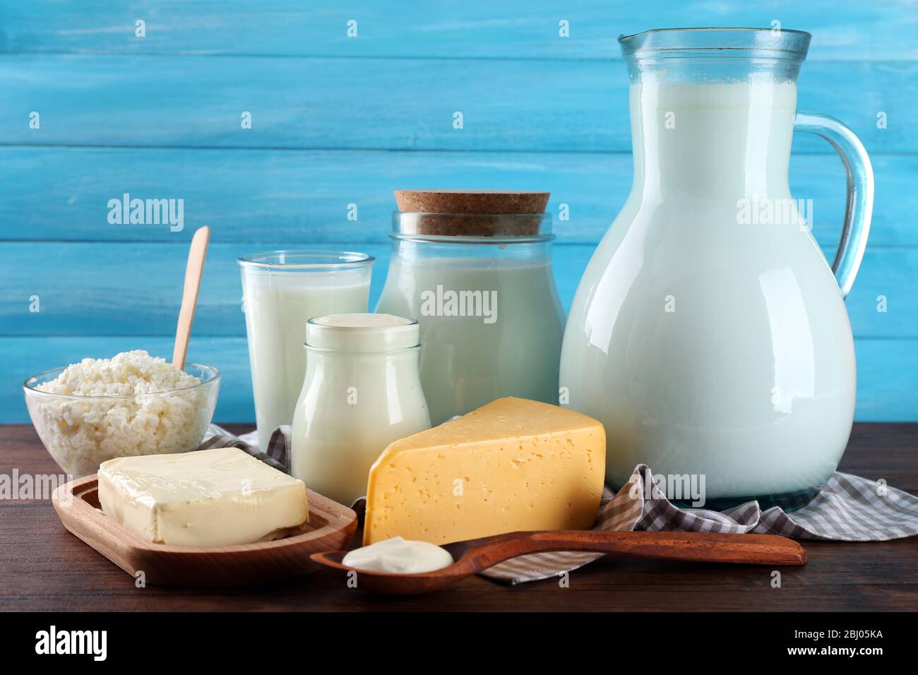 Dairy products on wooden table on blue background Stock Photo - Alamy