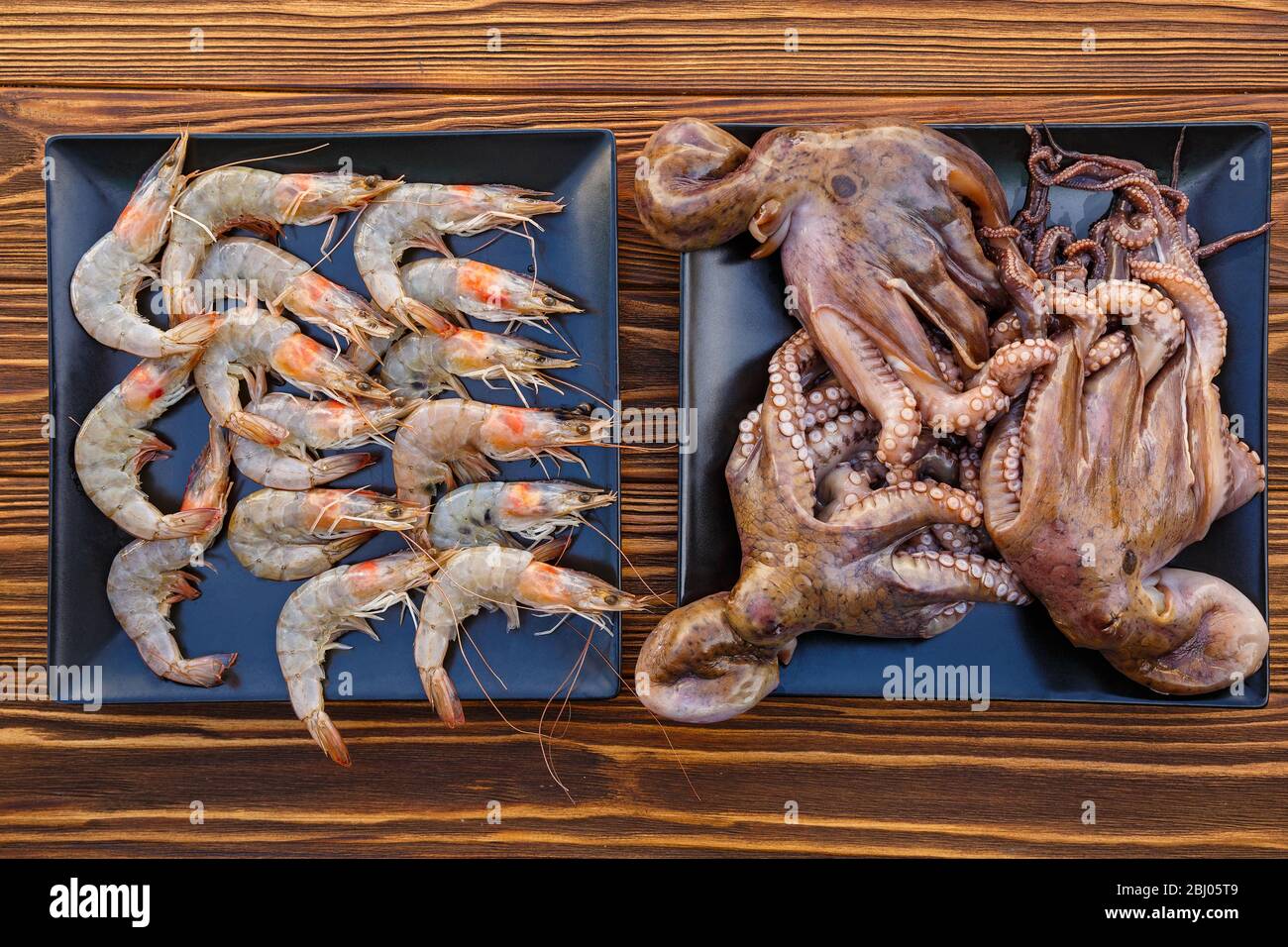 Two dishes with shrimp and octopus on a dark wooden background Stock ...