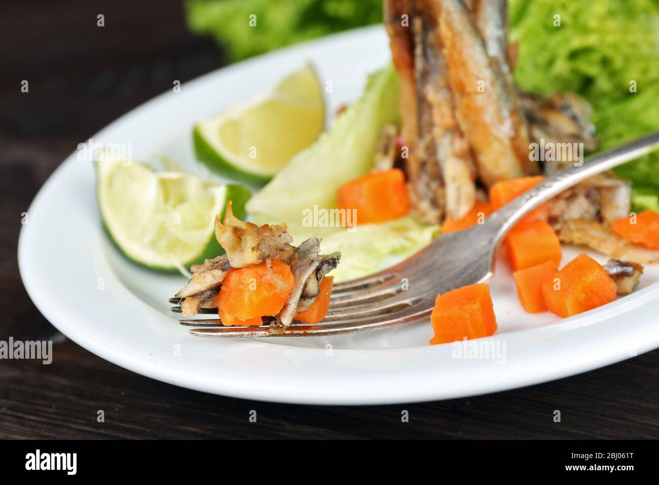 Fried small fish with carrot and greens on table close up Stock Photo ...