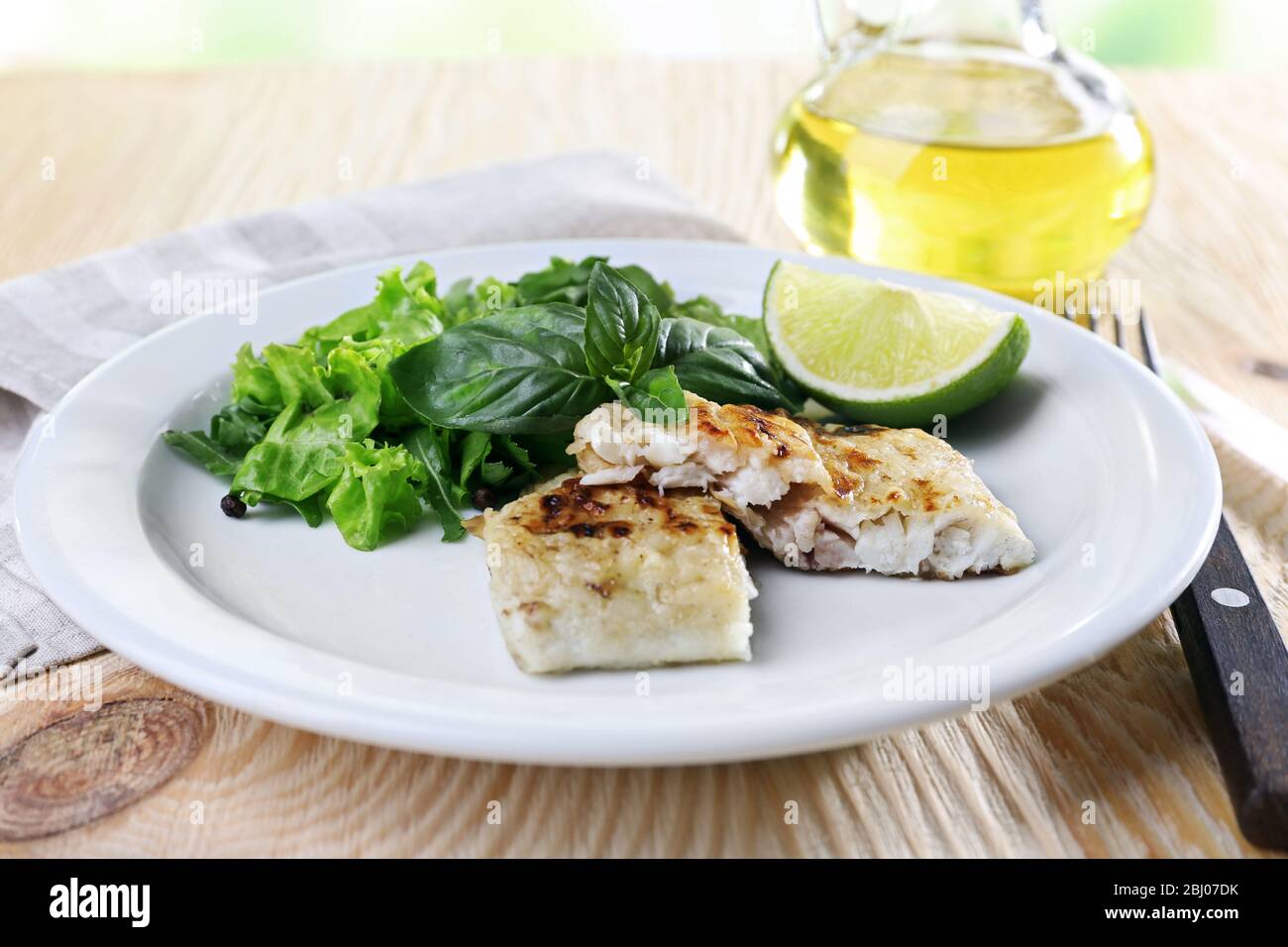 Dish of fish fillet with greens and lime on table close up Stock Photo ...