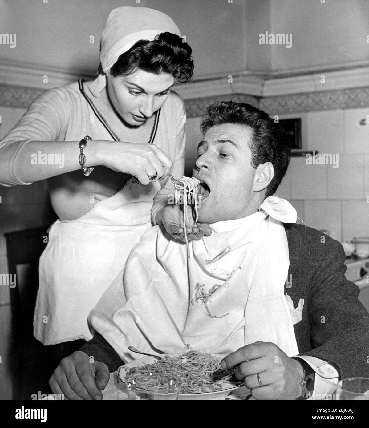 the art of eating speghetti - Woman helps her man to eat his spaghetti ...