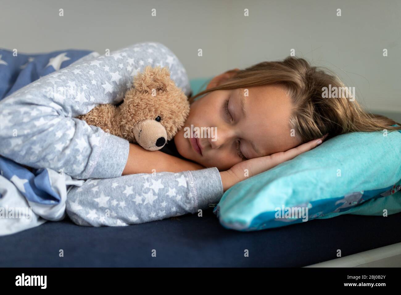 Girl is sleeping and cuddles with her teddy bear Stock Photo - Alamy