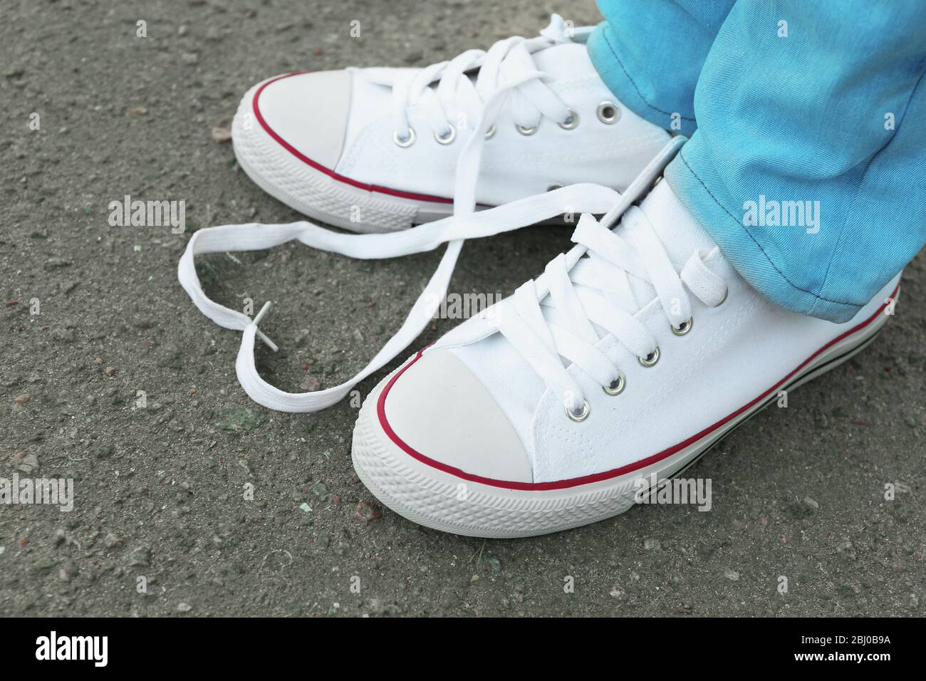 Female feet in gum shoes on asphalt background Stock Photo - Alamy