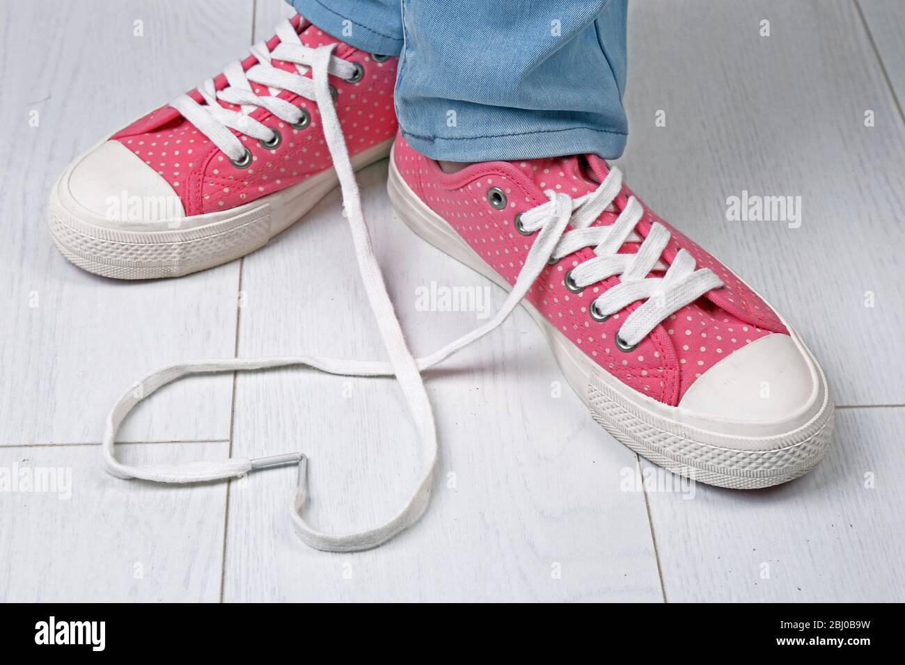 Female feet in gum shoes on wooden floor background Stock Photo - Alamy