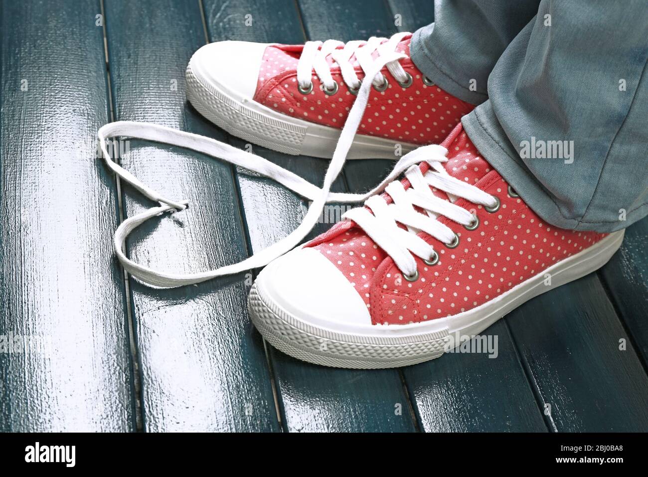 Female feet in gum shoes on color wooden background Stock Photo - Alamy