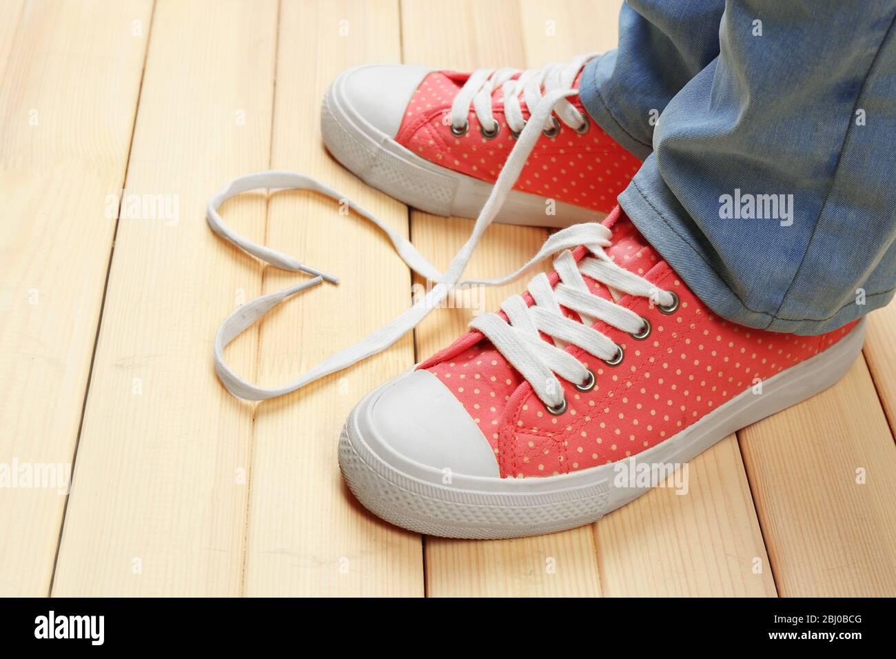 Female feet in gum shoes on wooden floor background Stock Photo - Alamy