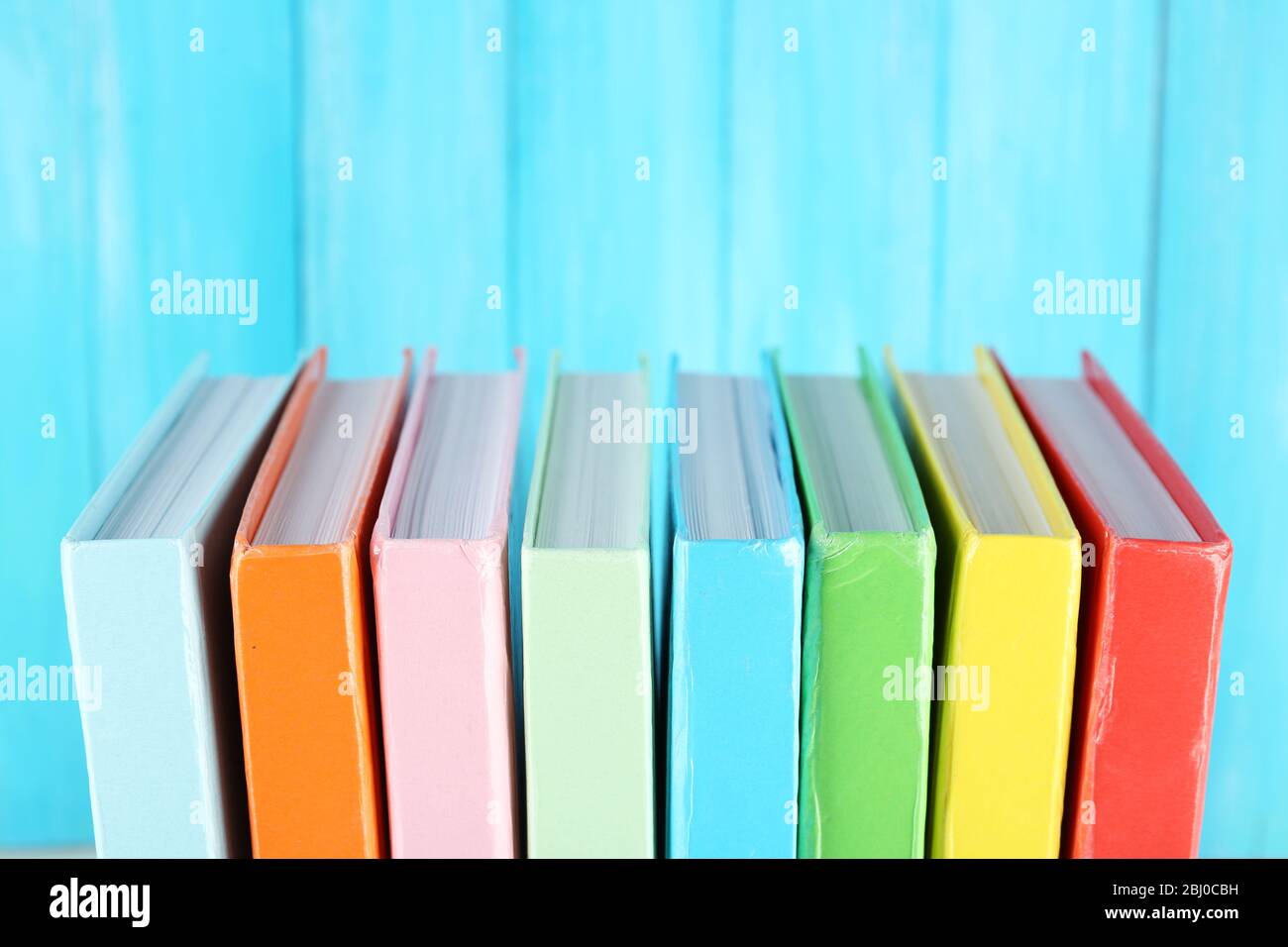 Colorful books on turquoise wooden background Stock Photo - Alamy