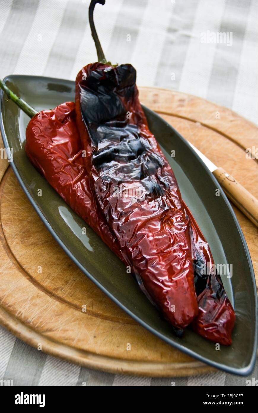 Long red sweet peppers grilled on barbecue showing blistered skin Stock ...