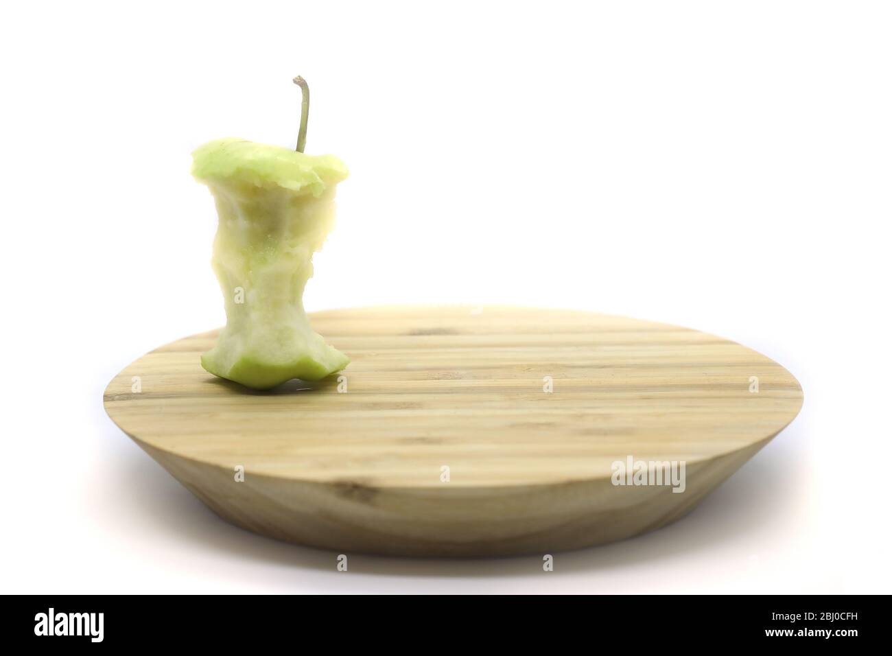 Green apple core on a wooden plate isolated on a white background Stock ...