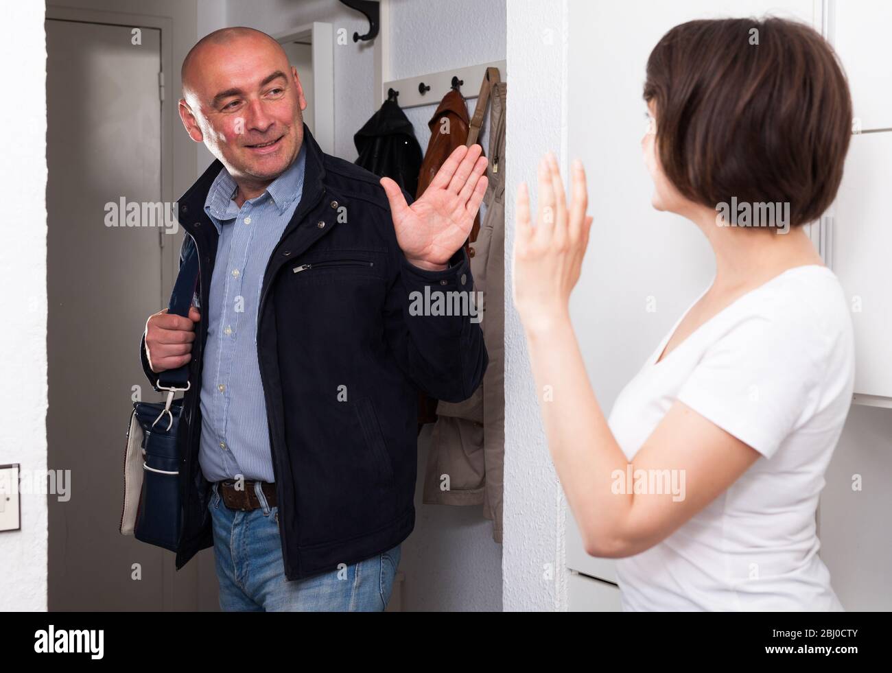 Woman says goodbye to her husband in the hallway of the apartment Stock ...