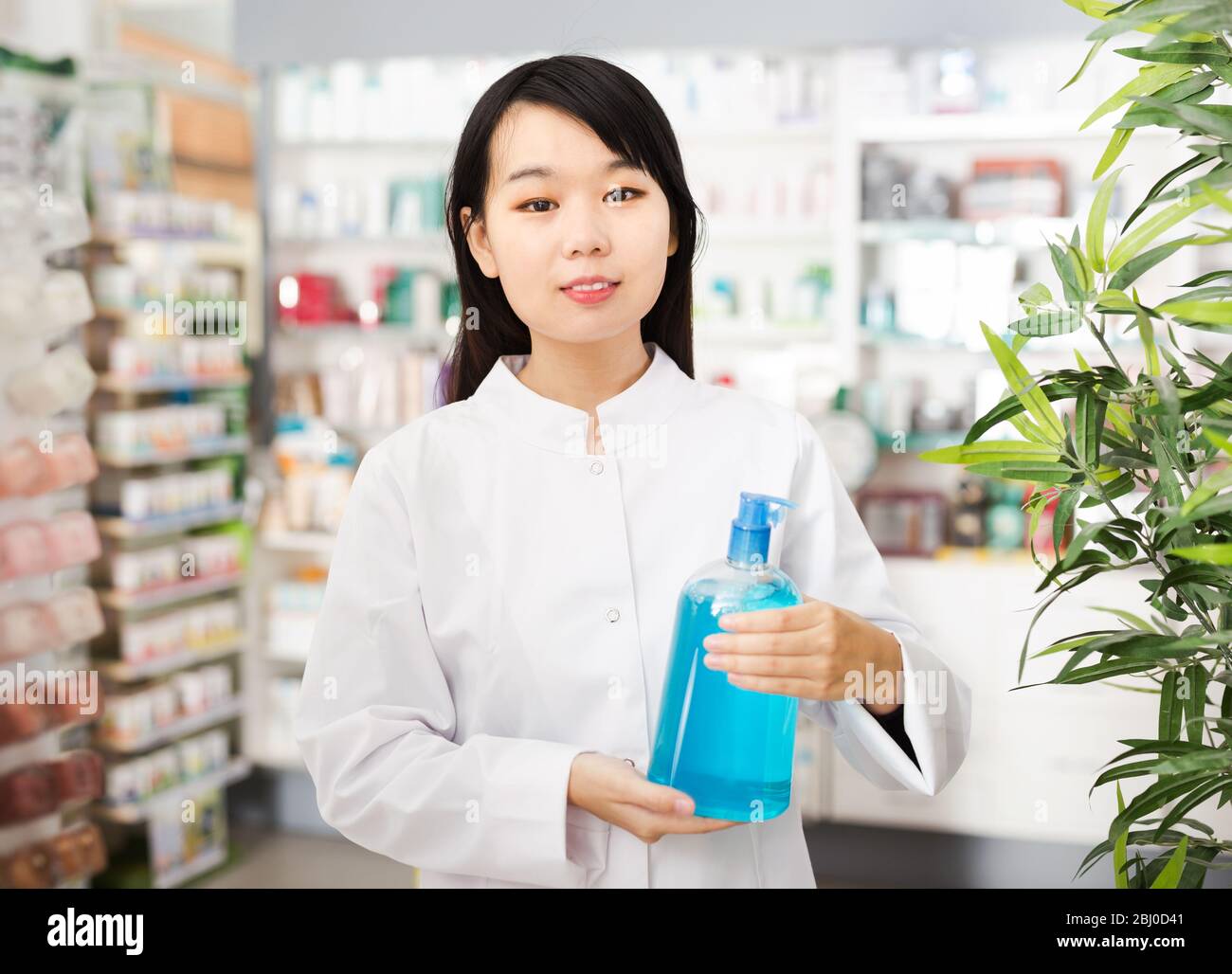 Portrait of chinese female pharmacist is standing with medicines in ...