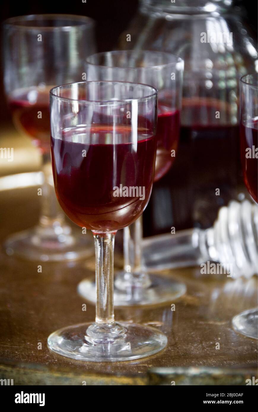 A tray of glasses of sloe gin with unstoppered decanter Stock Photo - Alamy