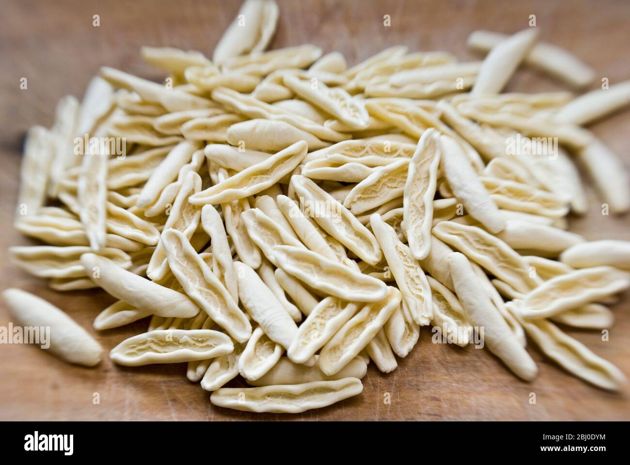 Raw cicatelli pasta shapes on wooden surface Stock Photo - Alamy