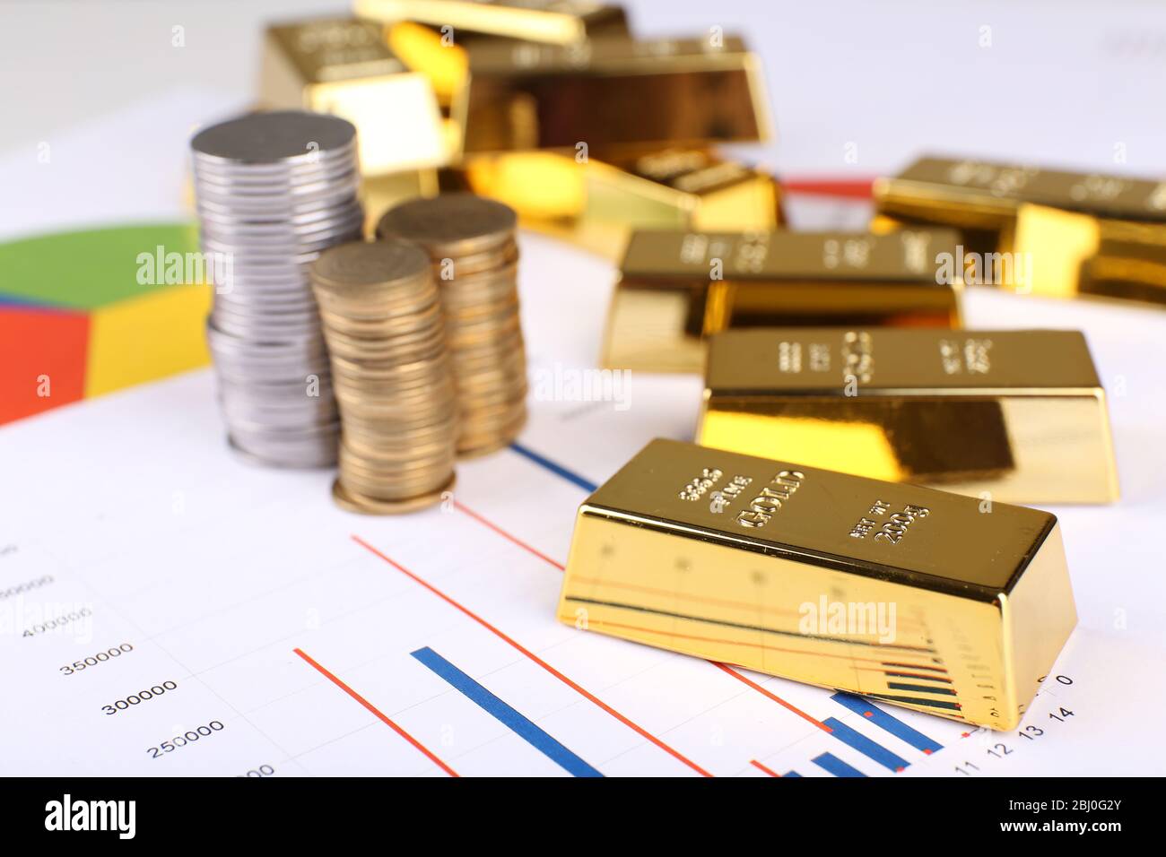 Gold bullion with coins on documents background Stock Photo - Alamy