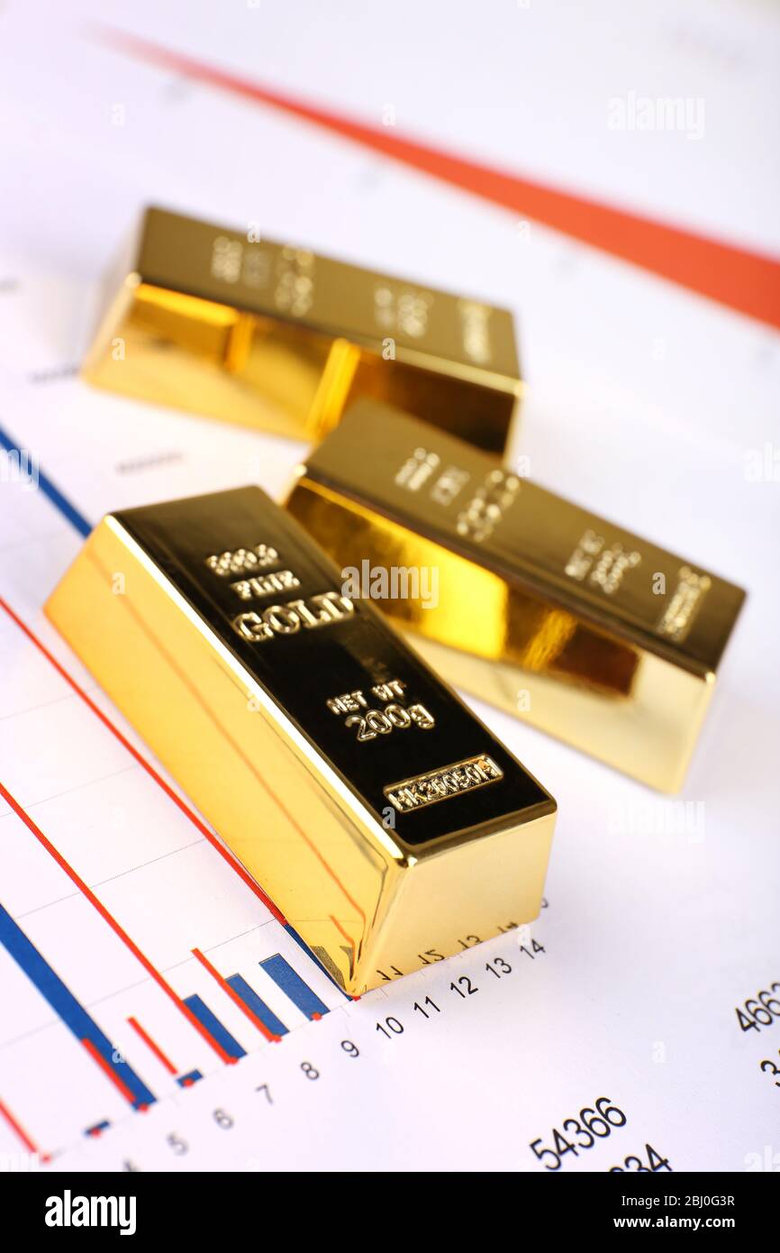 Gold bullion on documents background Stock Photo - Alamy
