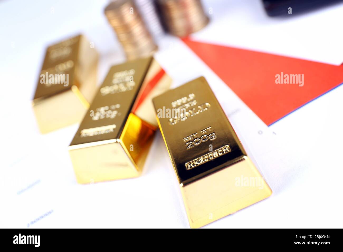 Gold bullion with coins on documents background Stock Photo - Alamy