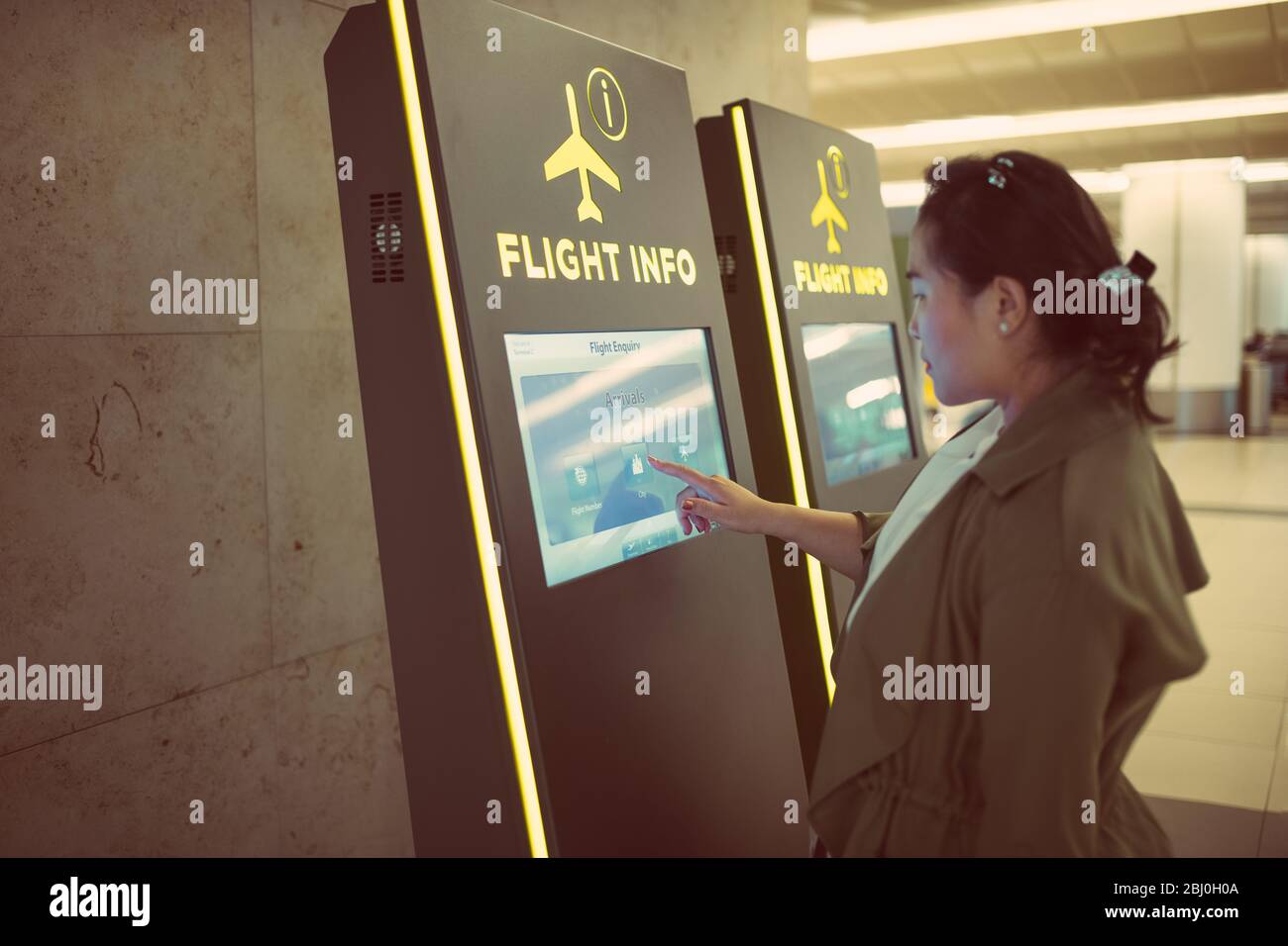 Young woman checking time at the flight info kiosk in the airport Stock ...