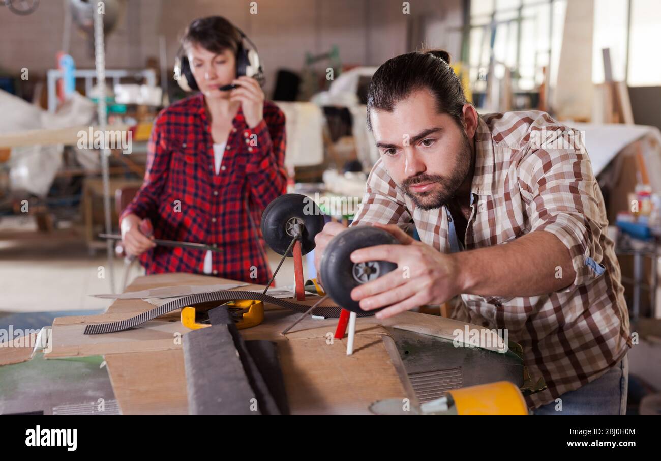 Young male hobbyist engaged in creating plane models in aircraft ...