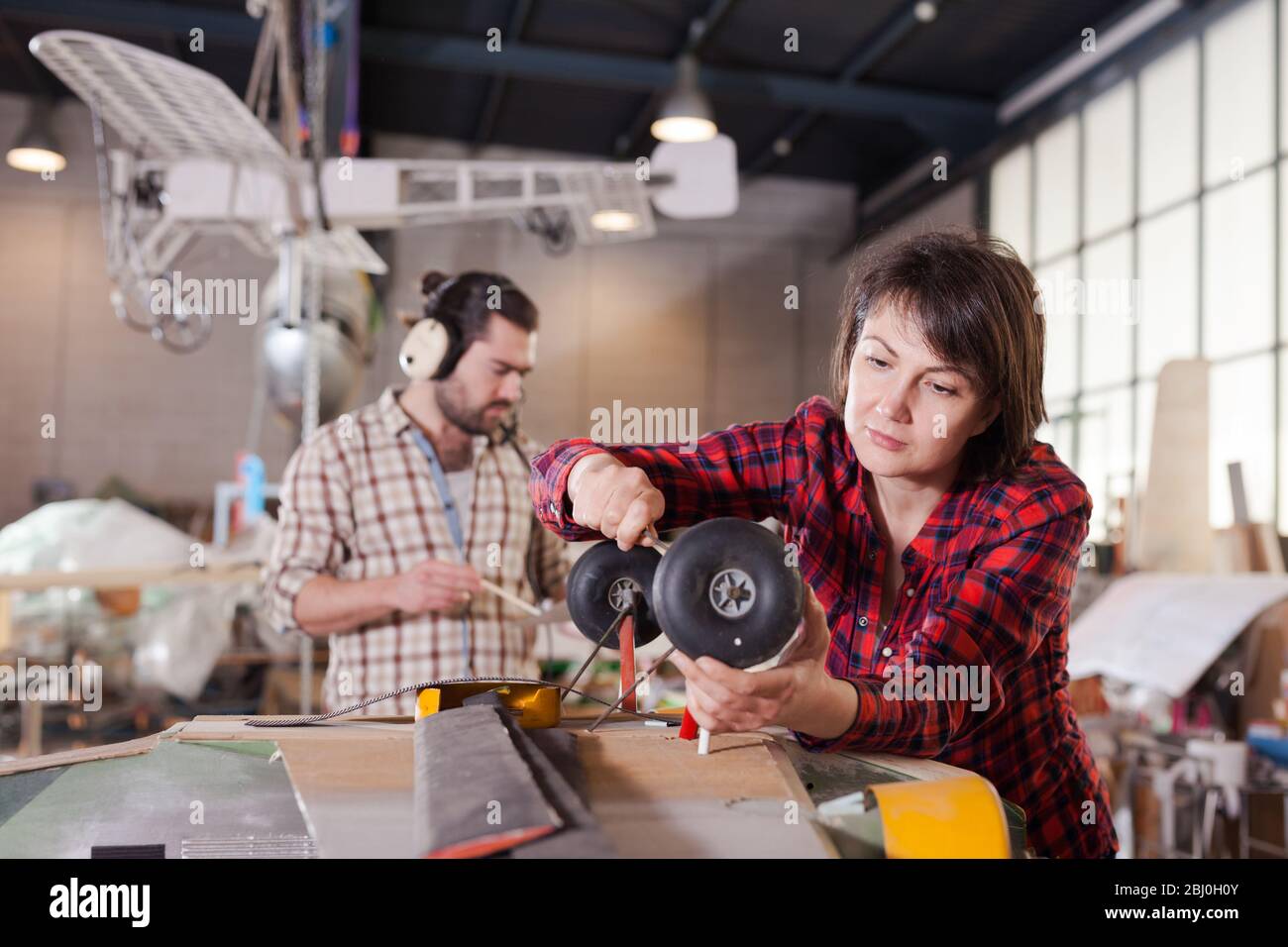 Young woman enjoying her hobby - modeling light airplanes in aircraft ...